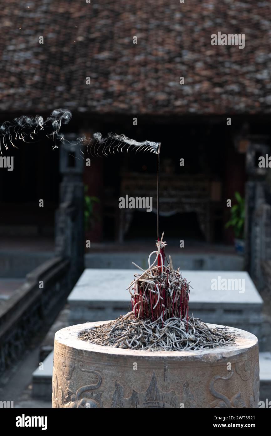 An offering of burning incense and smoke wafting through the air amid a ...