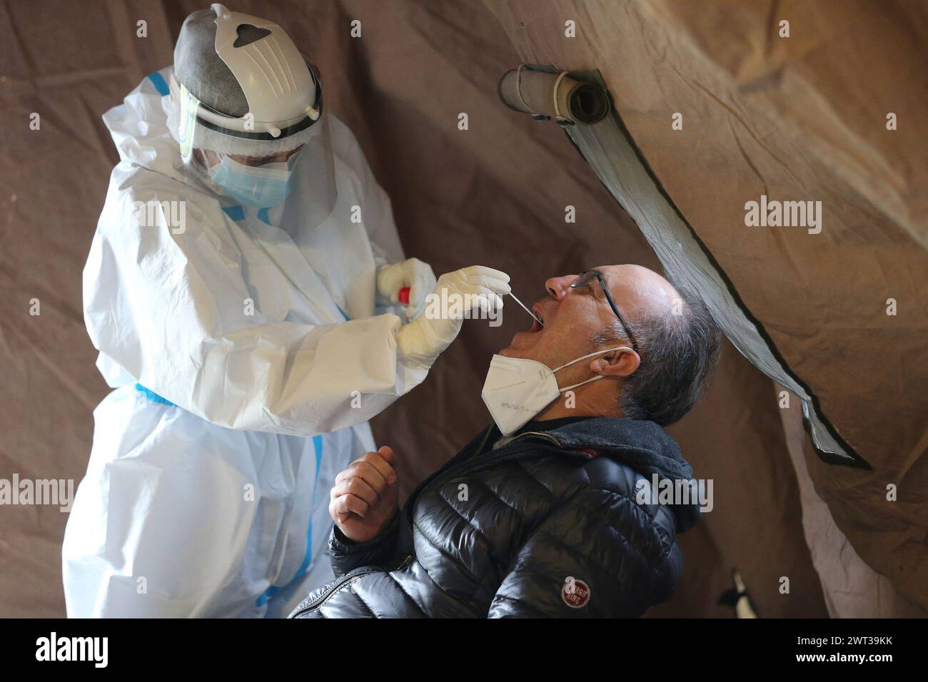 A doctor, dressed in overall and mask to protect himself, while ...