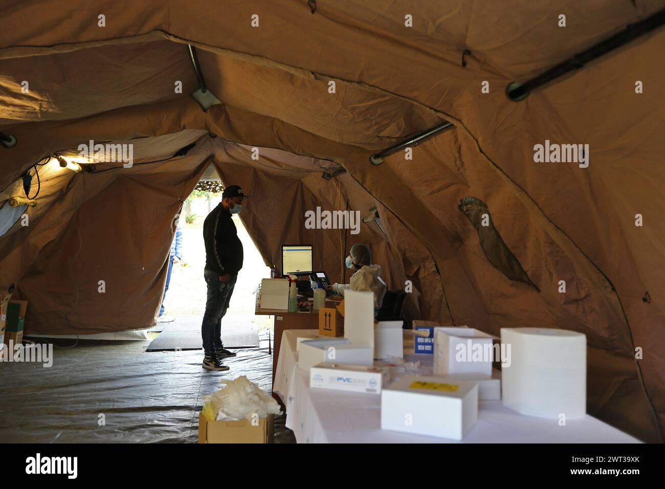A doctor, dressed in overall and mask to protect himself, check the ...
