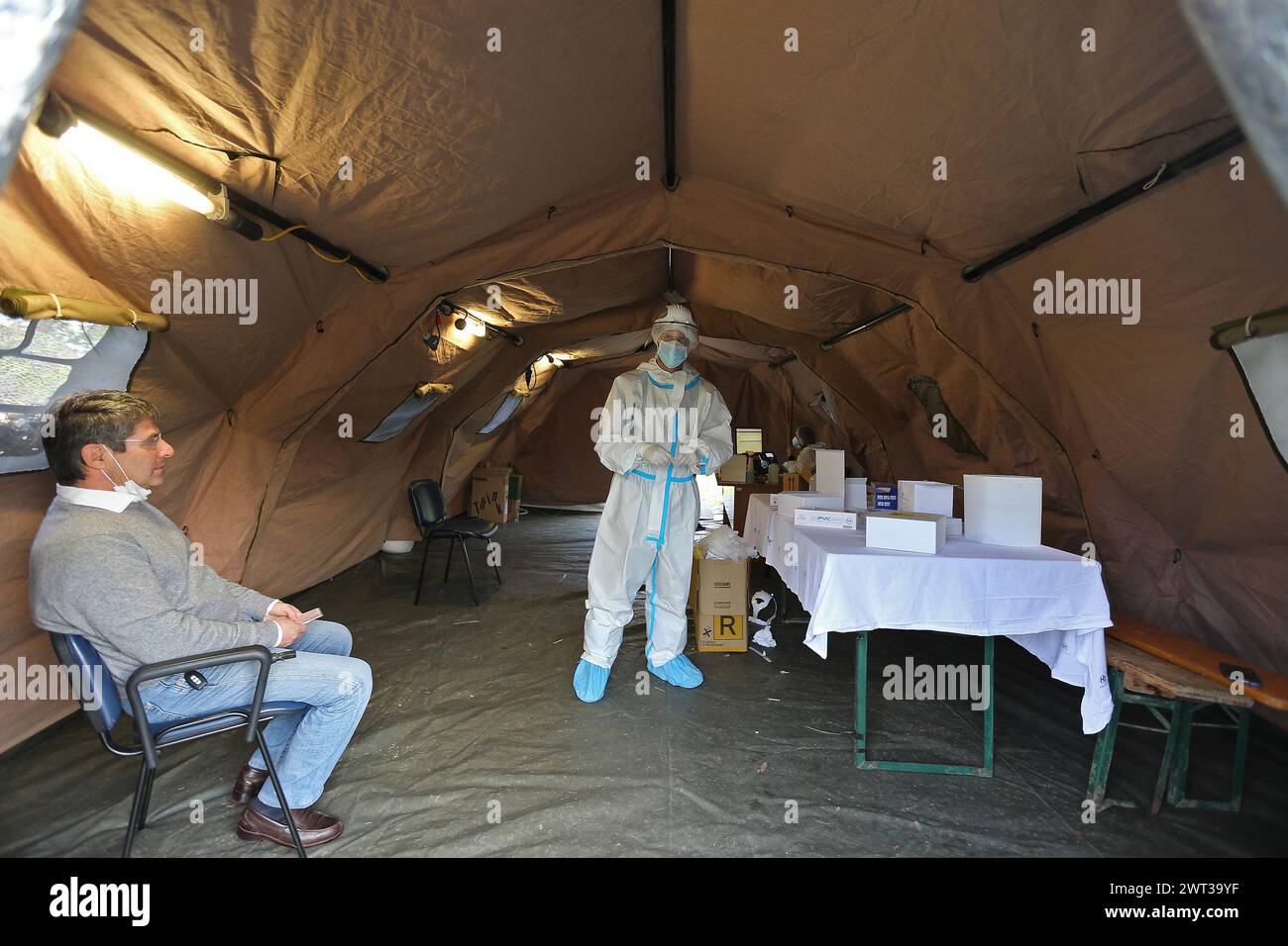 A doctor, dressed in overall and mask to protect himself, before ...