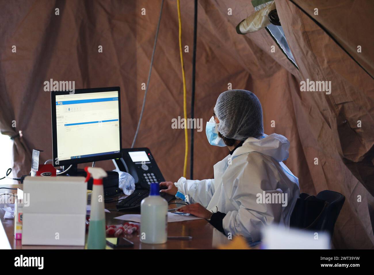 A doctor, dressed in overall and mask to protect himself, check the ...