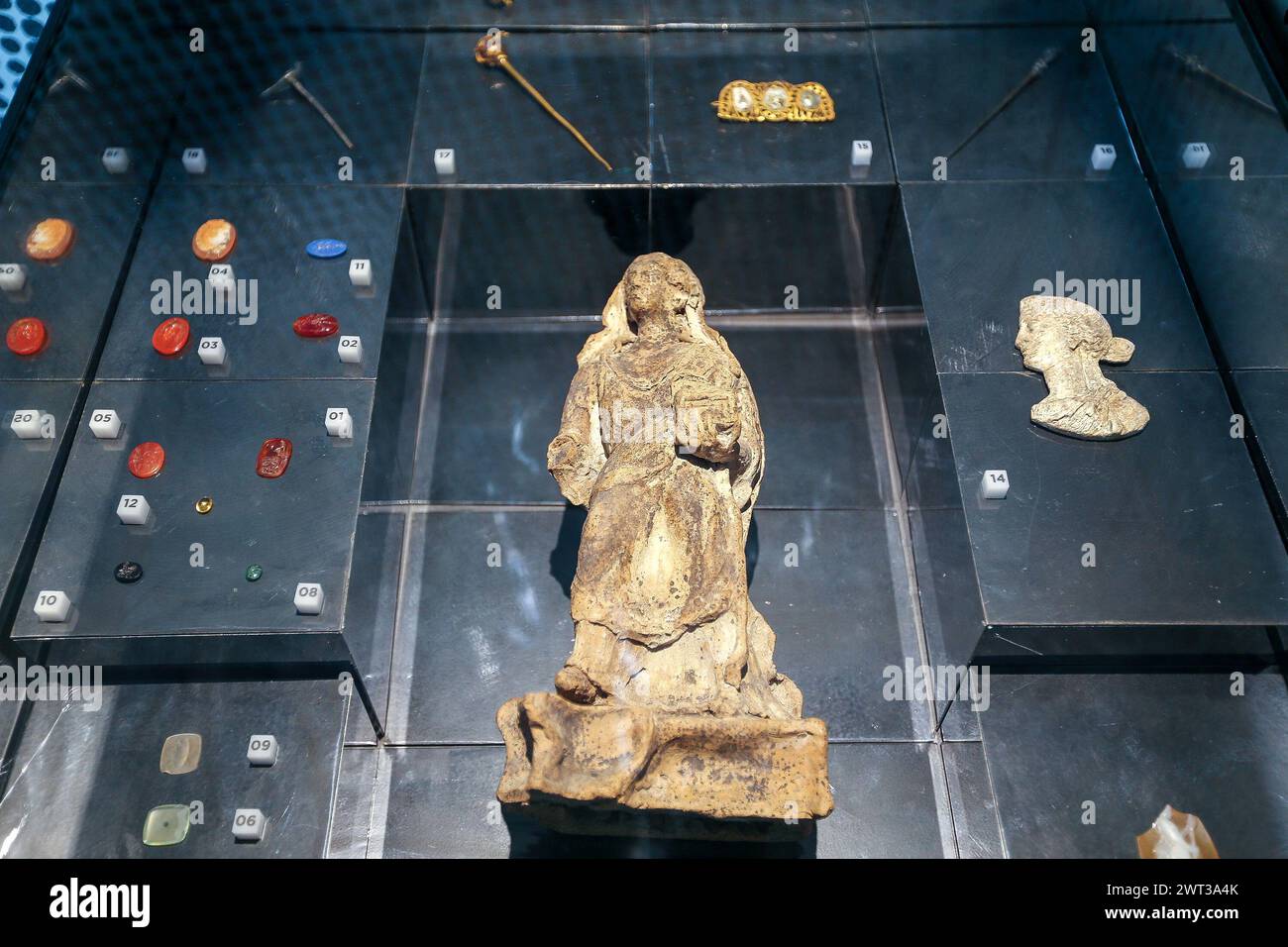 Ancient pompeian objects, including a statue and precious stones, inside the Venustas exhibition ...