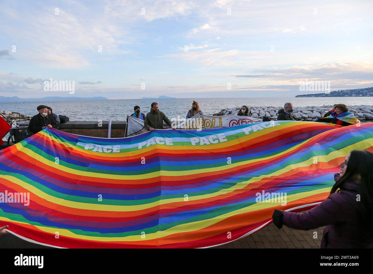 People, with a giant flag in the colors of the rainbow, on the Naples ...