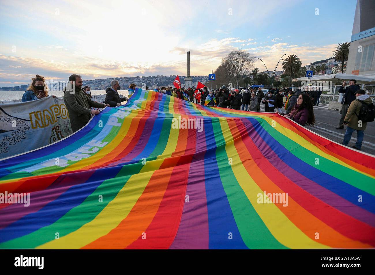 People, with a giant flag in the colors of the rainbow, on the Naples ...