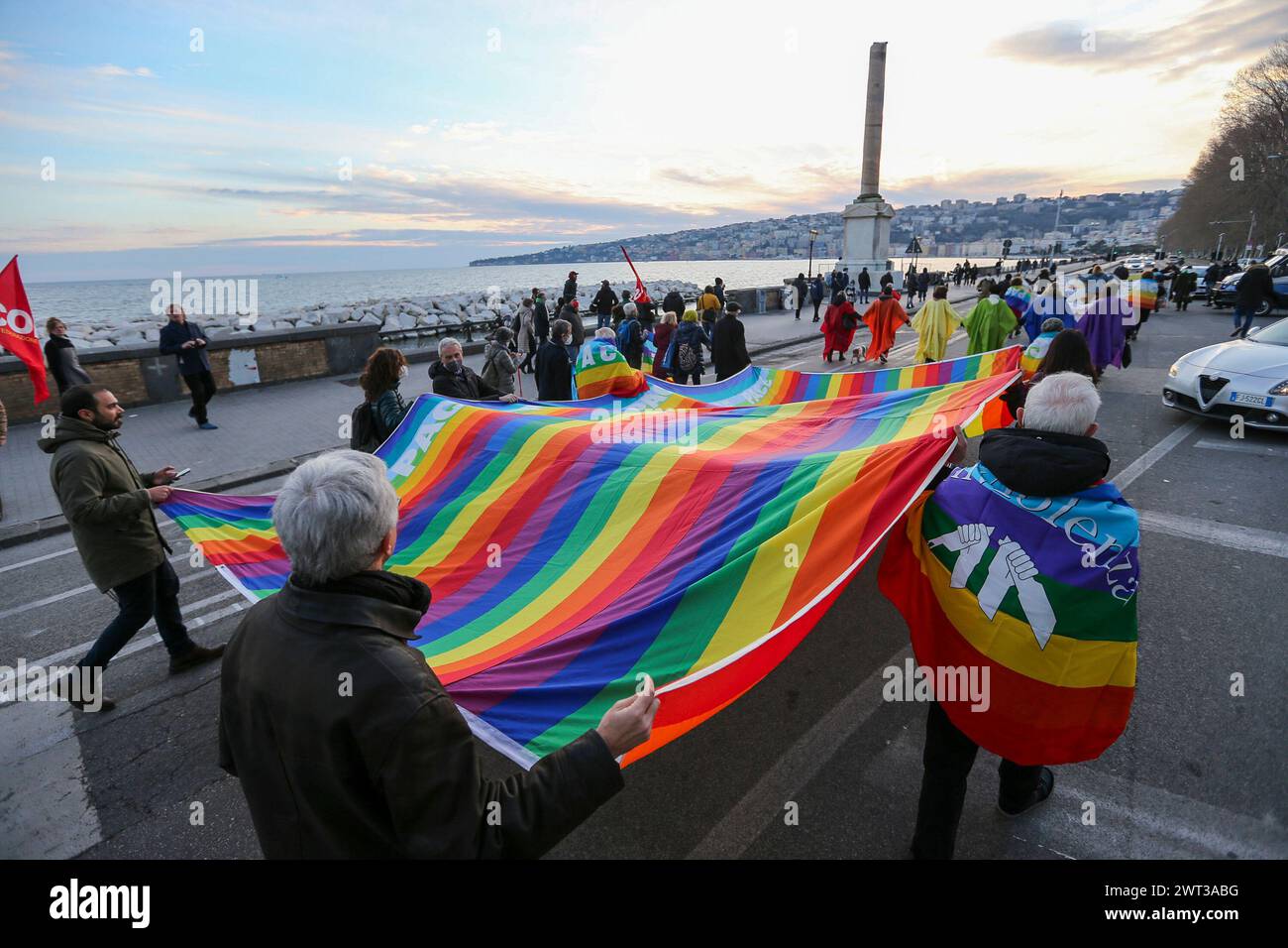 People, with a giant flag in the colors of the rainbow, on the Naples ...