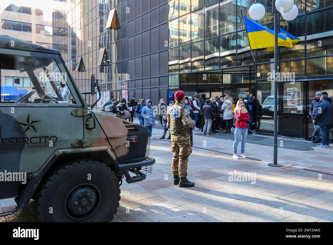 Italian soldiers on guard in front of the line of Ukrainian refugees ...