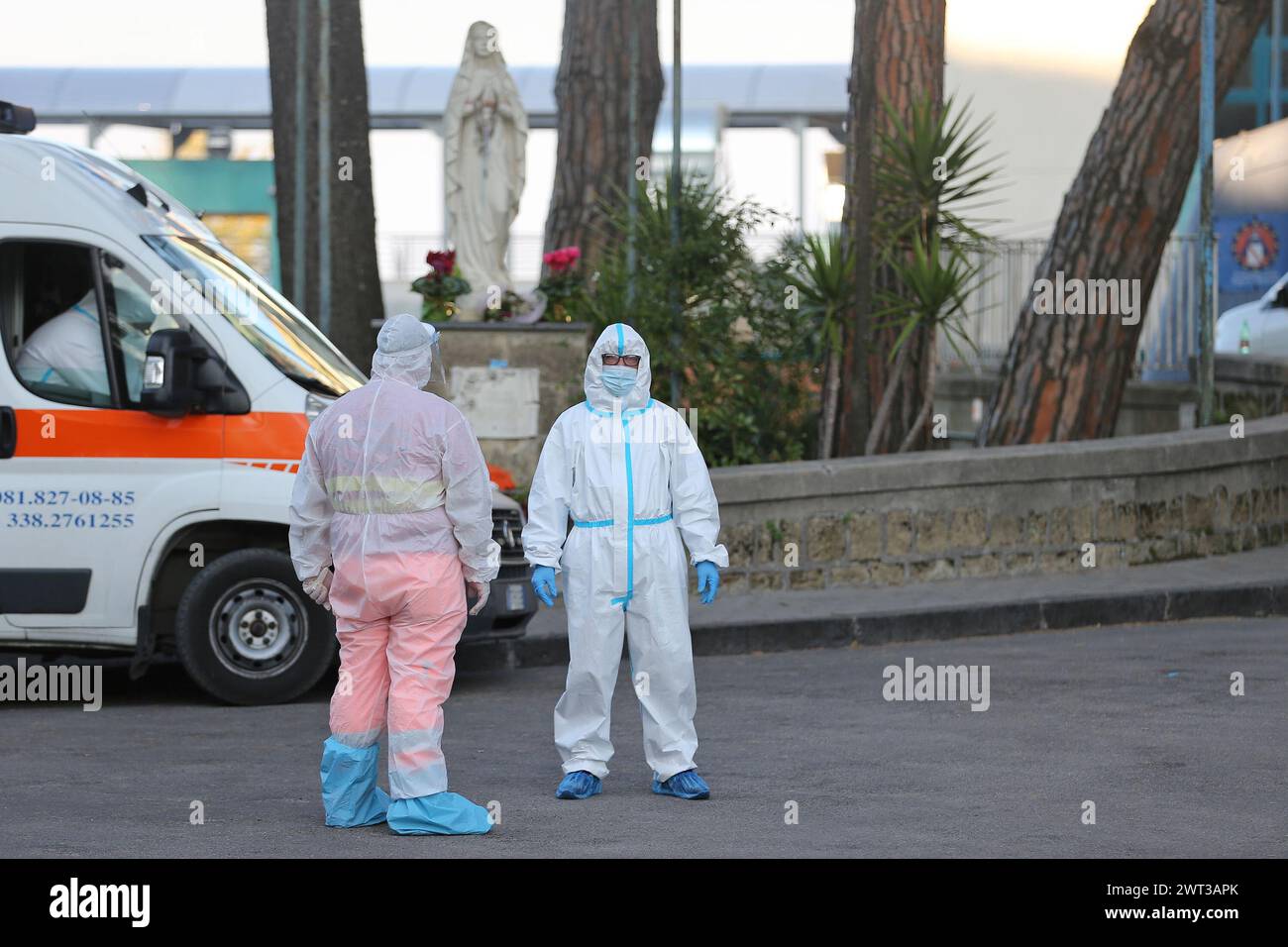Doctors, dressed in overall and masks to protect themselves, near an ...