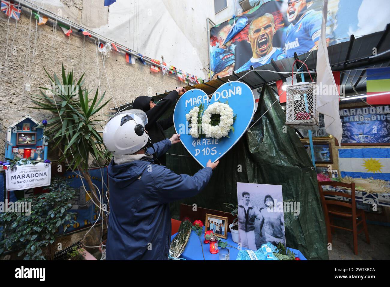 Two men hang a giant heart dedicated to Diego Armando Maradona, in the ...