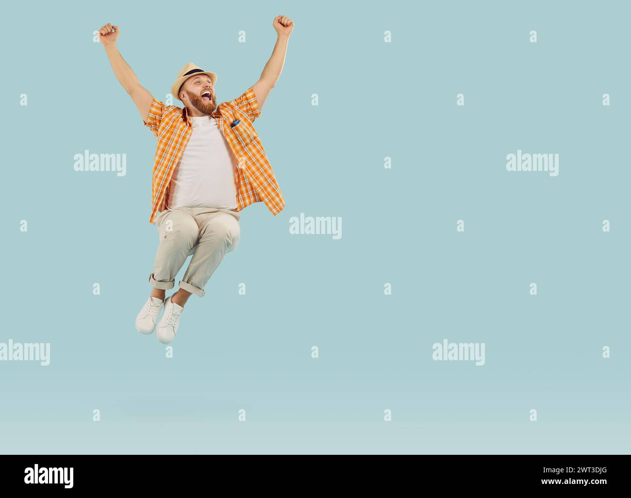Joyful man celebrating success with victorious shout and jump on pastel ...