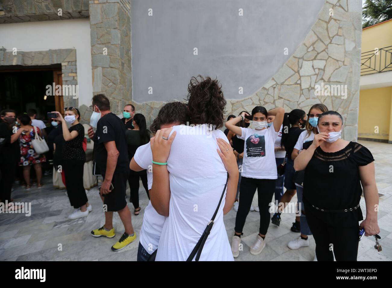 Two girls hug each other in front of the church before the funeral of ...