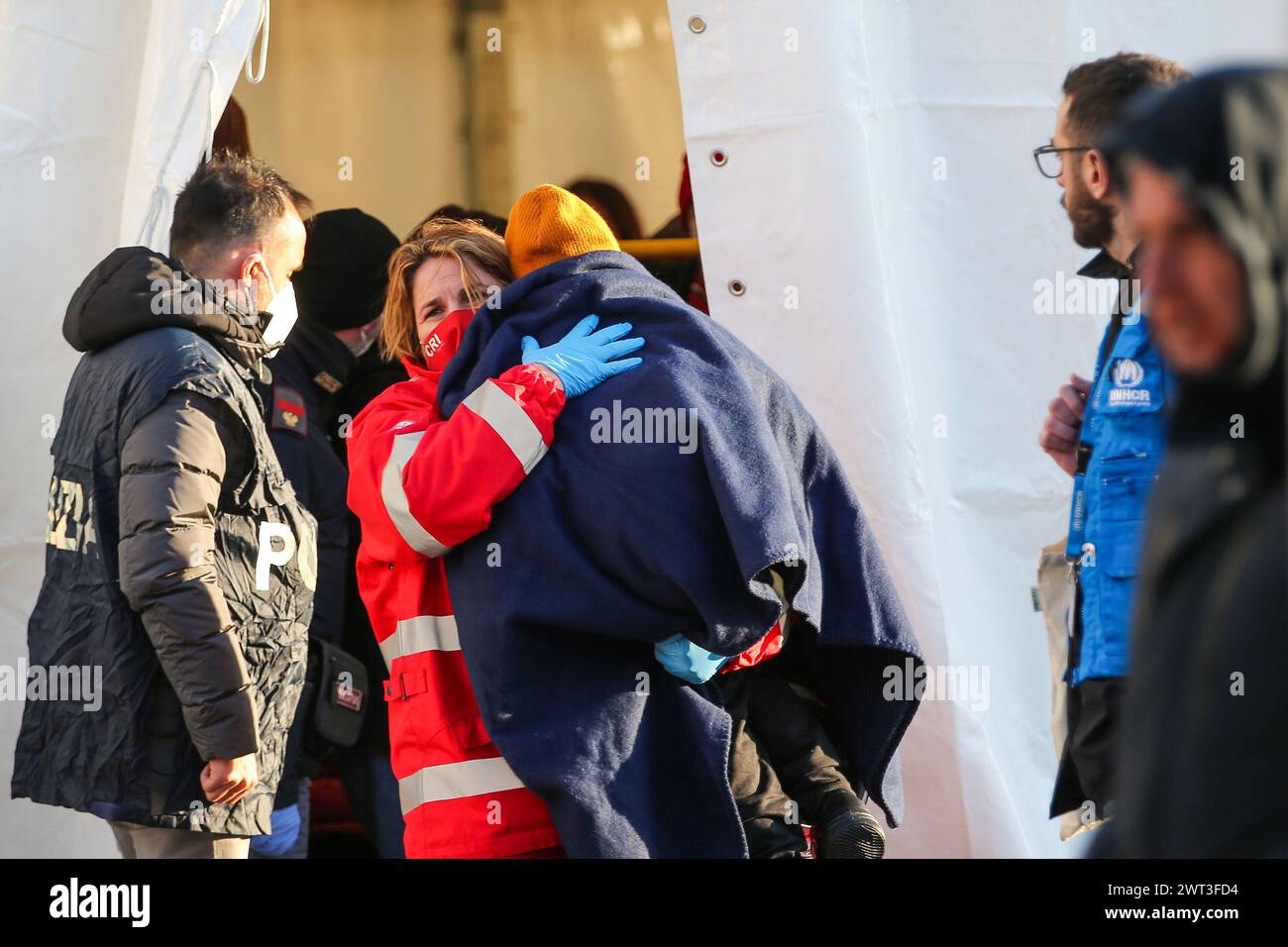 A migrant child with a rescuer during the checks after disembarking in ...