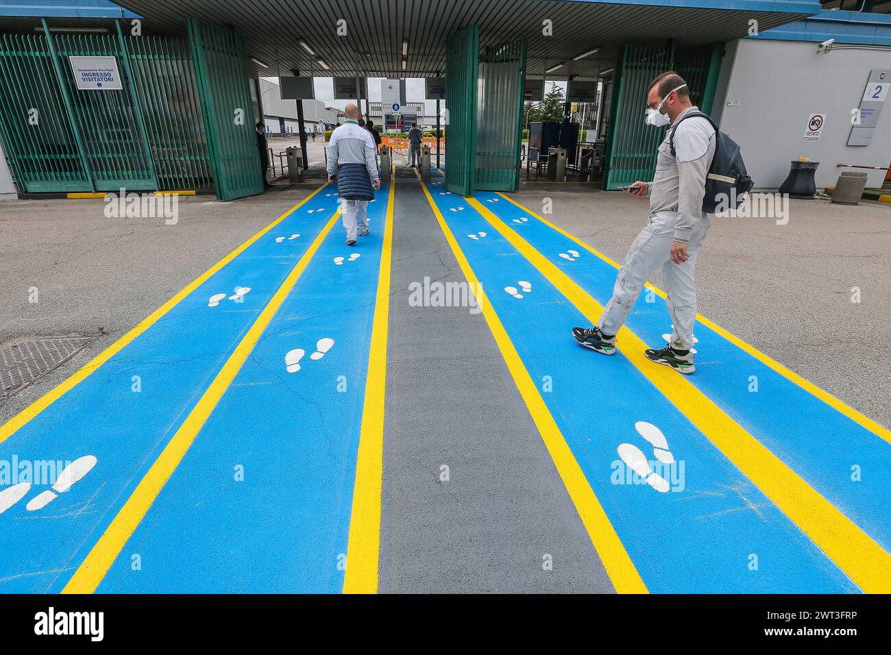 Workers, upon arrival at the just reopened Gian Battista Vico Plant of ...