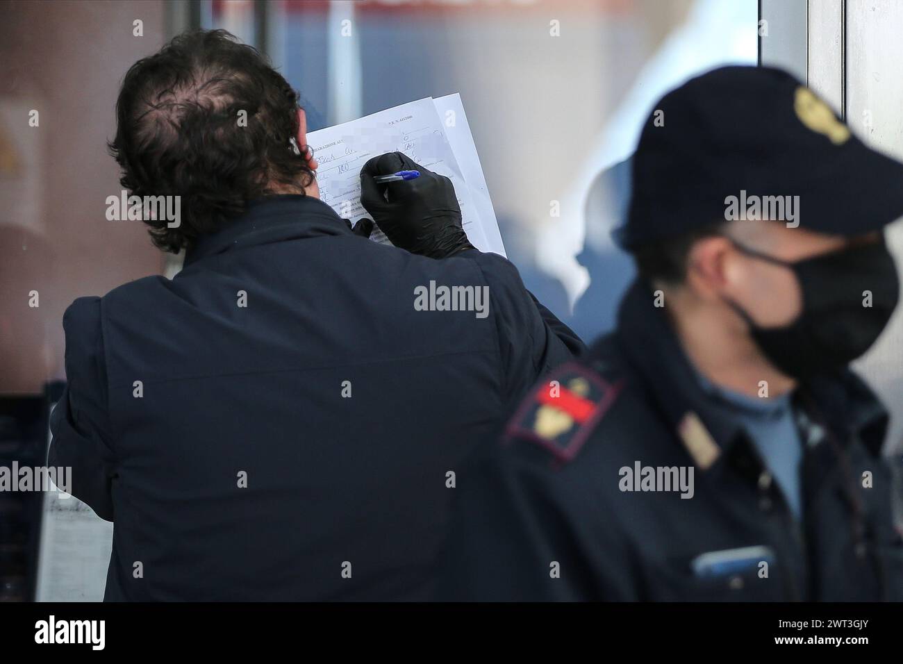 A man completes a self-declaration to a policeman, in the Naples ...
