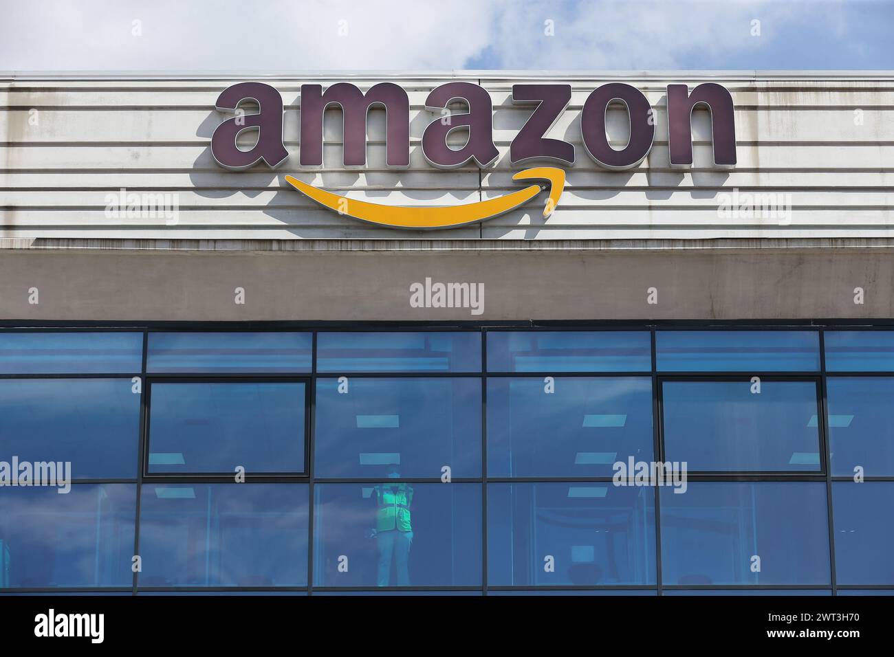 A view of the Amazon headquarters in Arzano, with a worker behind the ...
