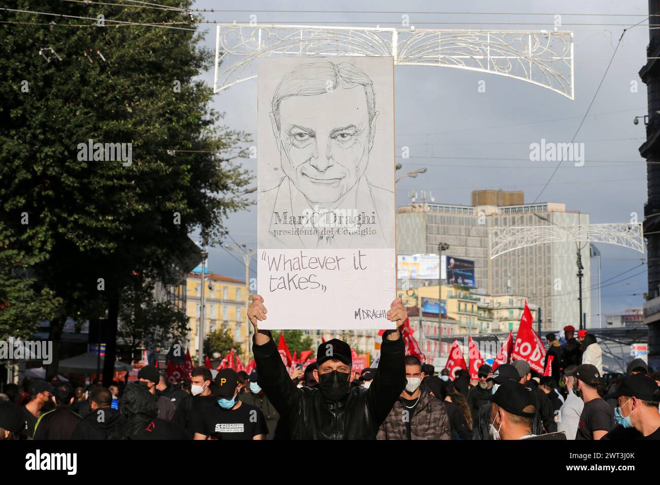 A man (with a mask to protect against Covid-19) with a placard ...