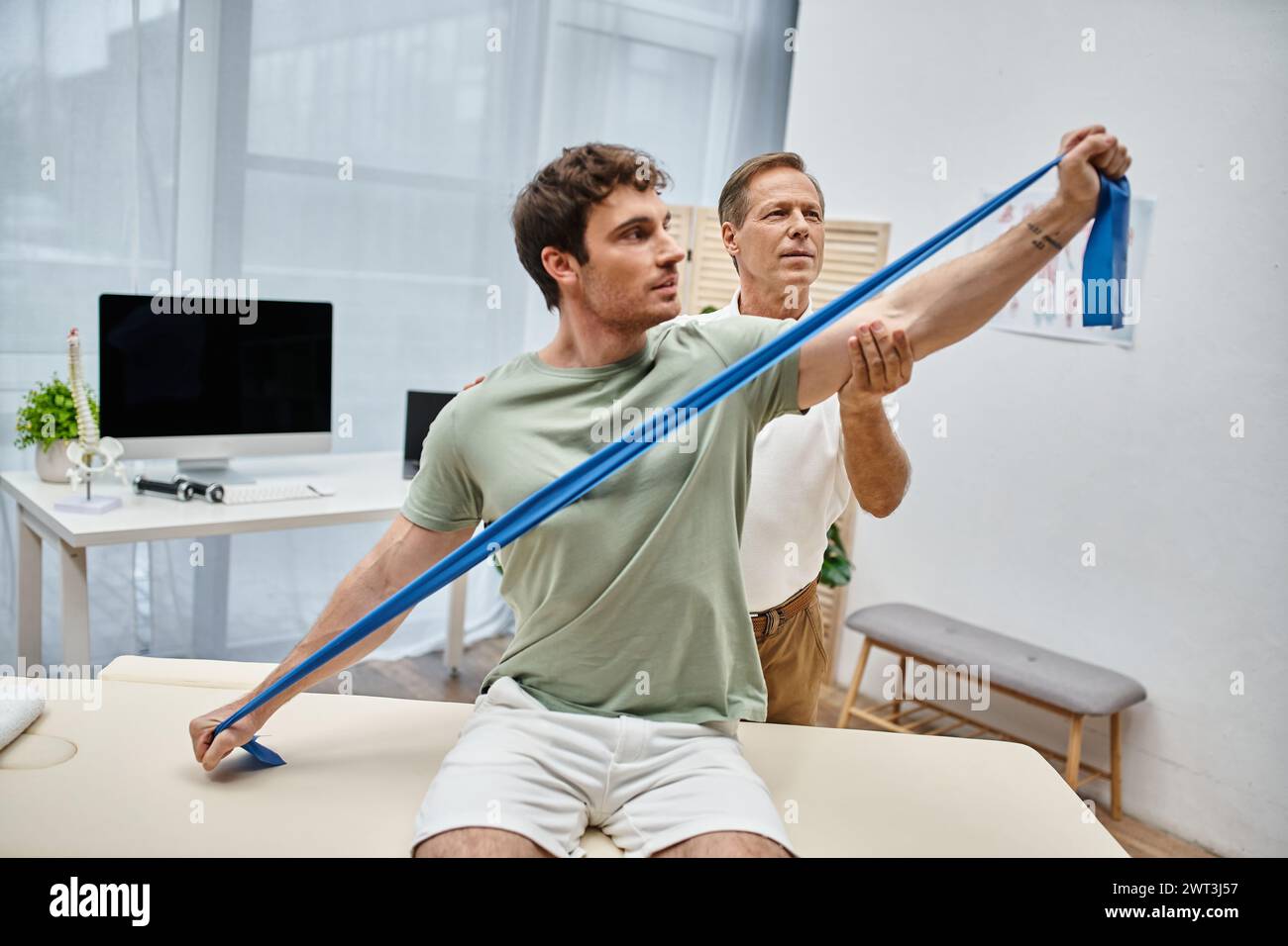 attractive man stretching his muscles with resistance band near his ...