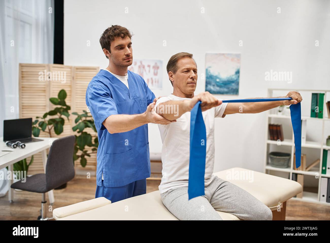 attractive doctor in blue robe helping his mature patient with ...
