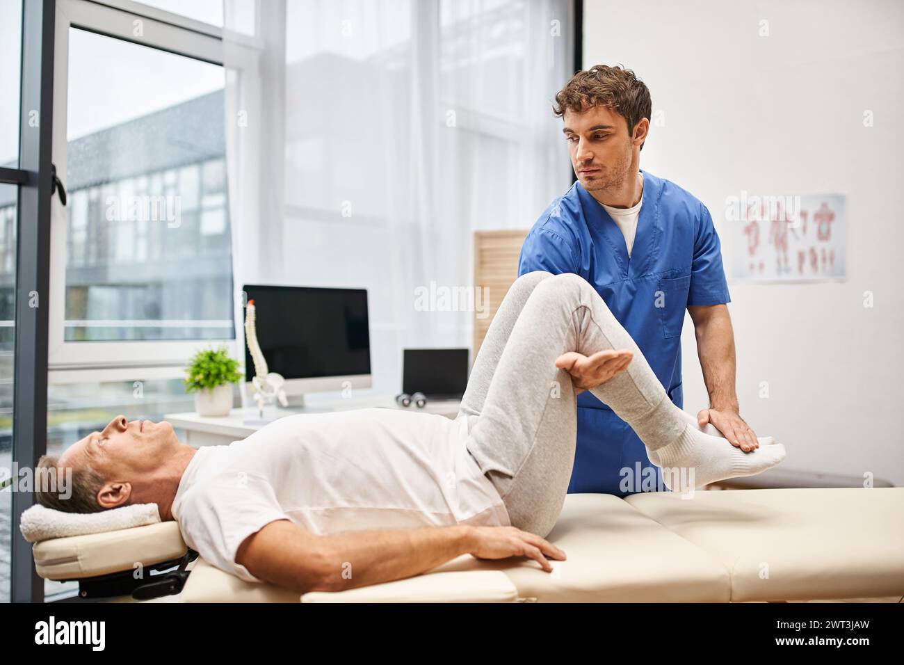 good looking doctor in blue robe helping his handsome mature patient to ...