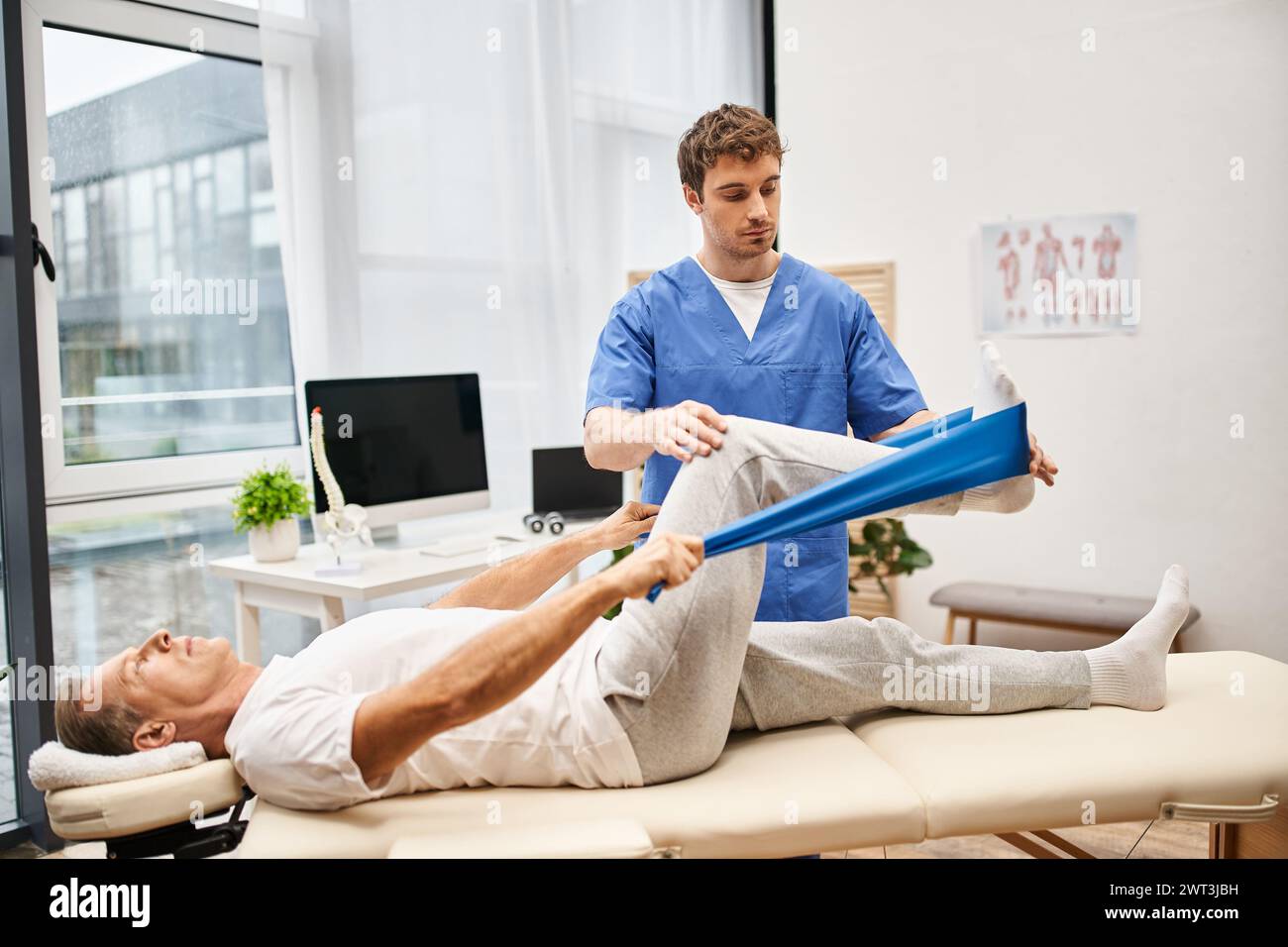 good looking doctor in blue robe helping his handsome mature patient ...