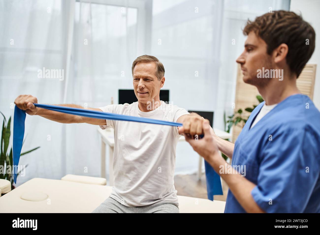handsome devoted doctor in blue robe helping his mature jolly patient ...
