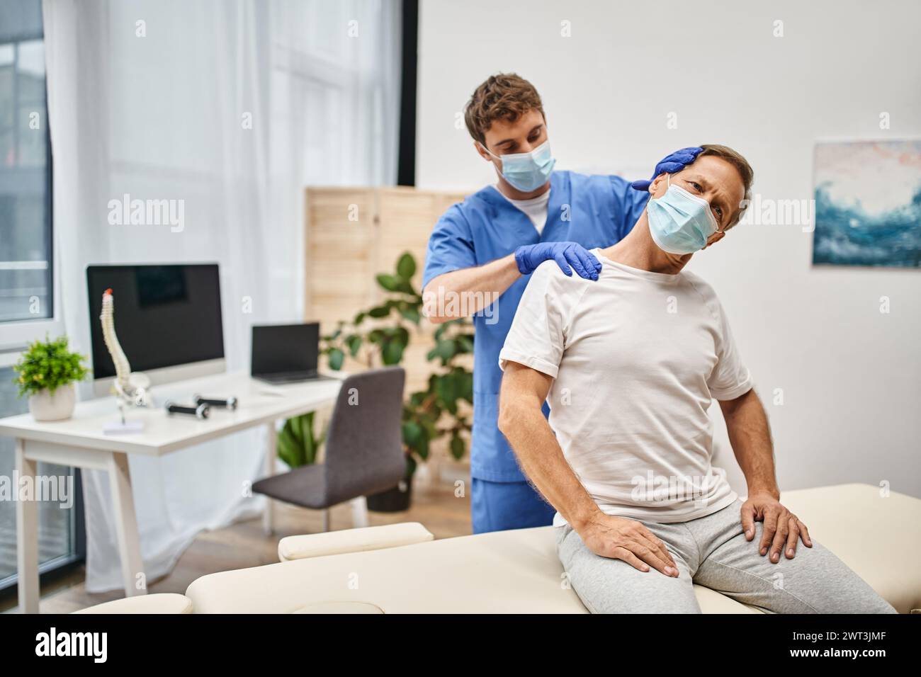 hardworking handsome doctor with mask stretching his patient during ...