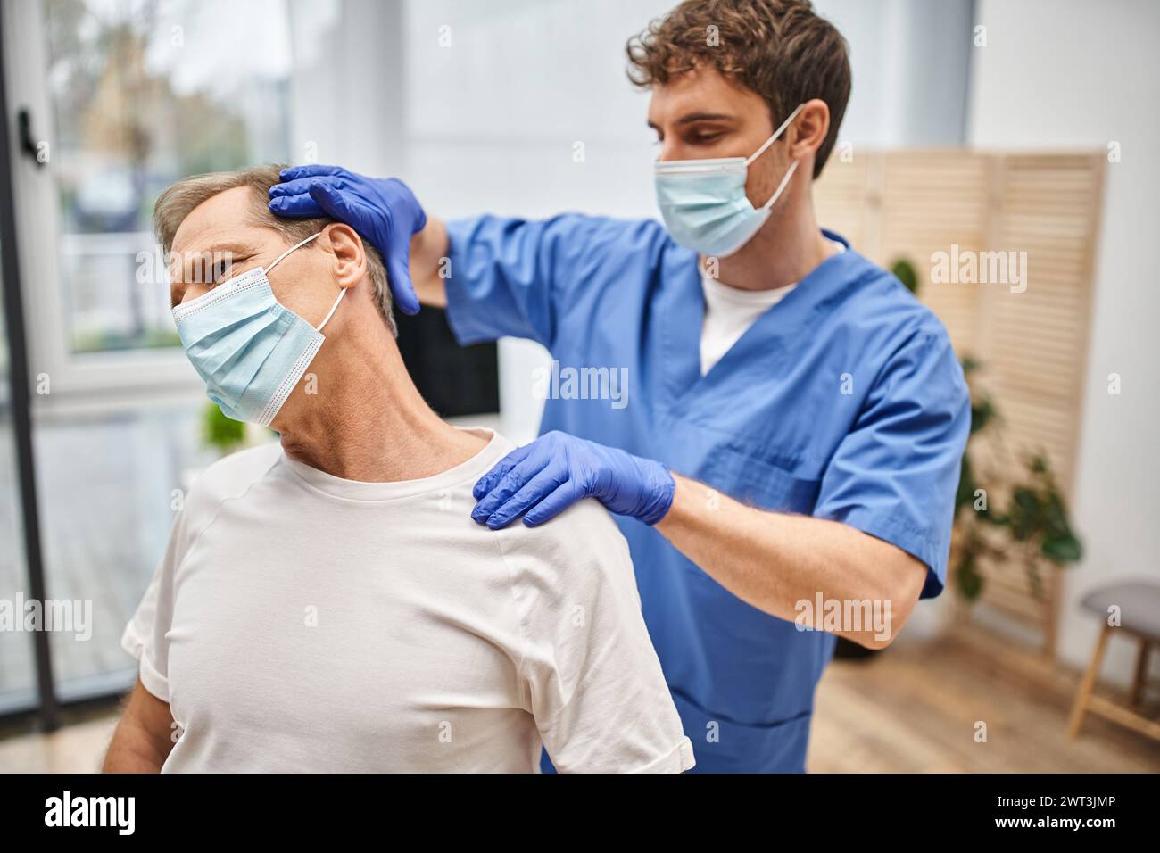 handsome dedicated doctor with mask and gloves stretching his mature ...