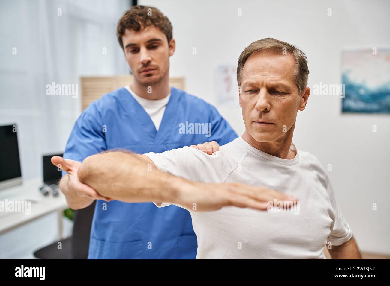 good looking dedicated doctor in blue robe helping his patient to ...