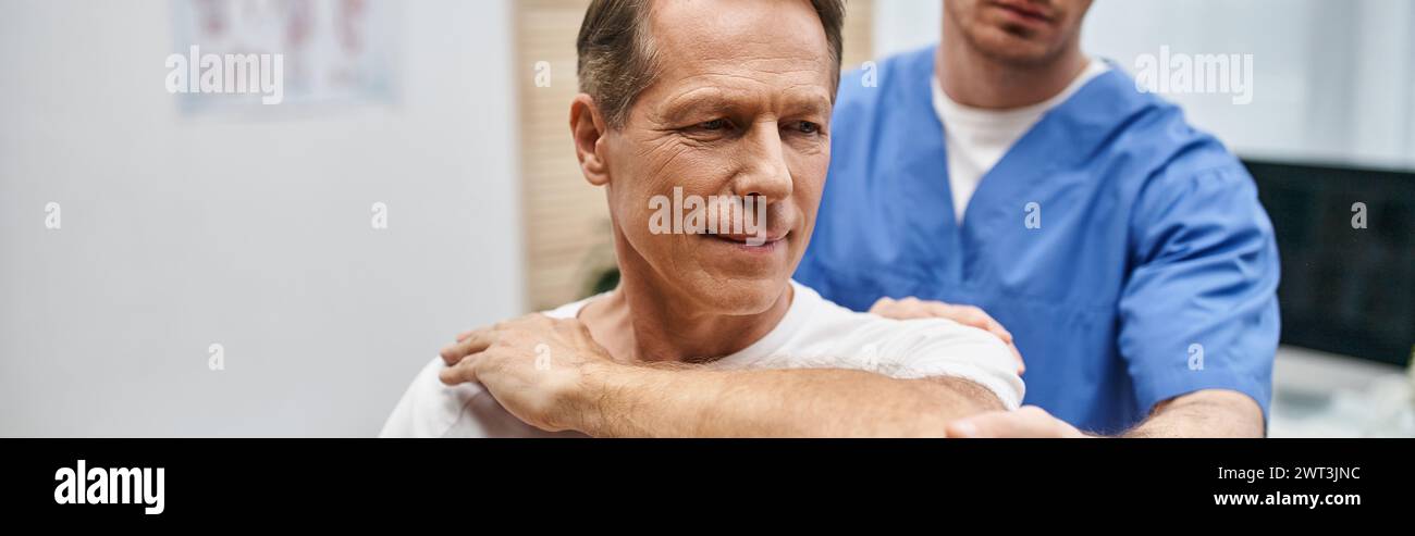 mature handsome patient stretching his muscles on rehabilitation with ...