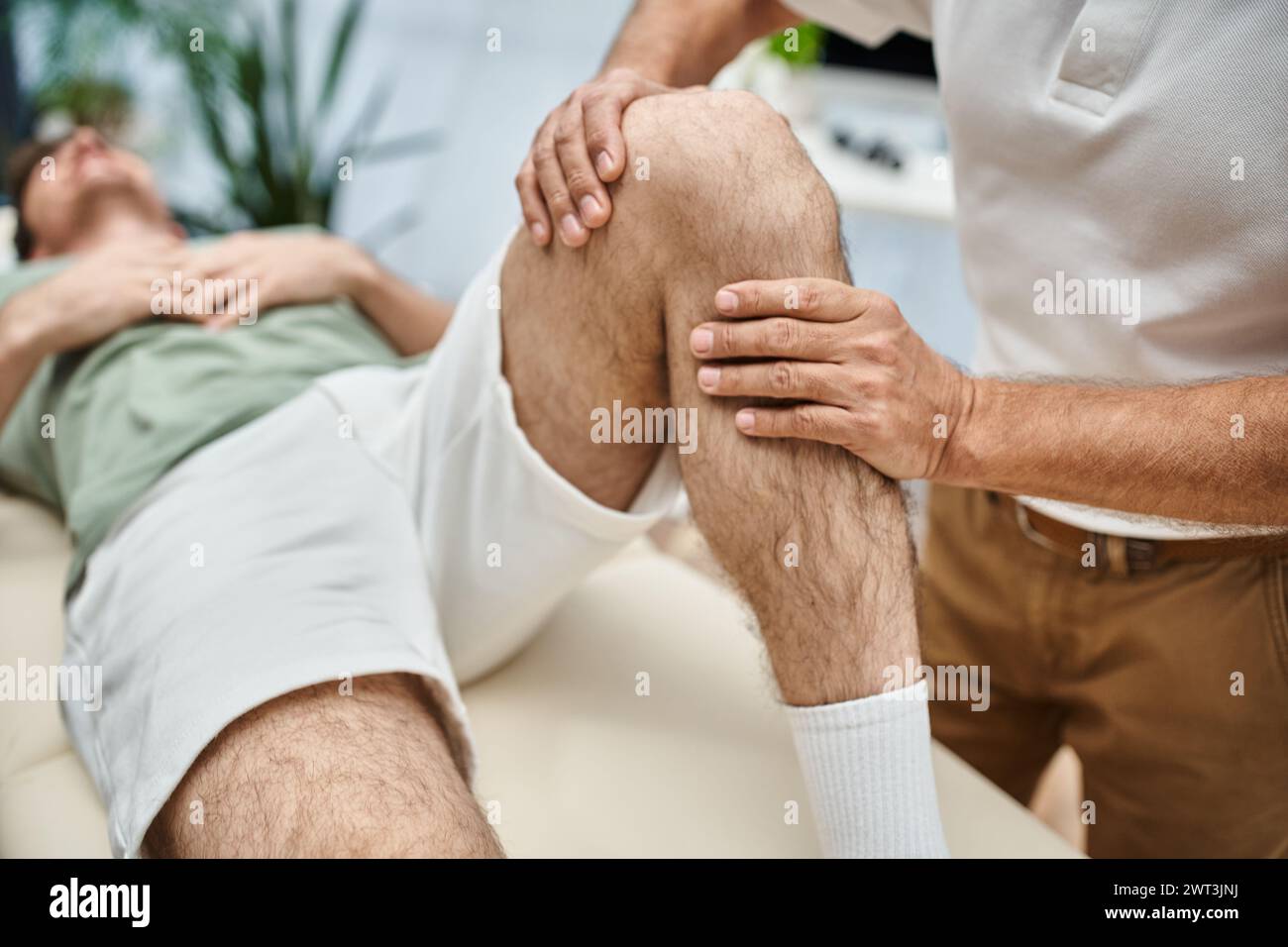 cropped view of mature doctor helping his patient to rehabilitate his ...