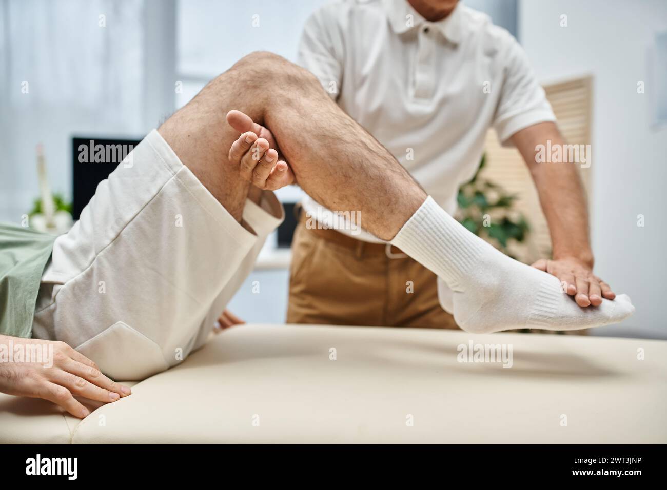 cropped view of mature doctor working with his patient and stretching ...