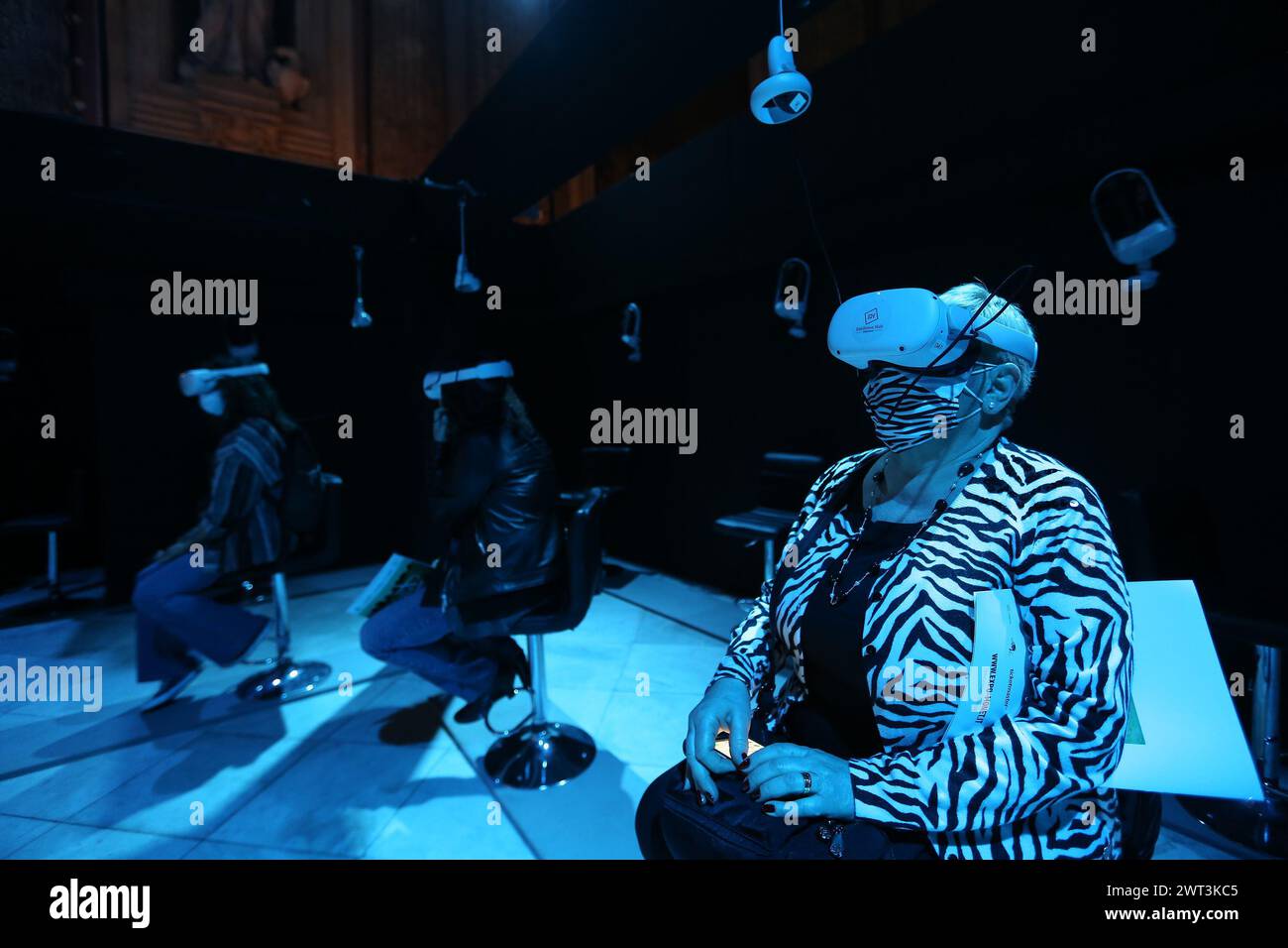 Visitors, with a mask to protect themselves from Covid-19, wear virtual ...