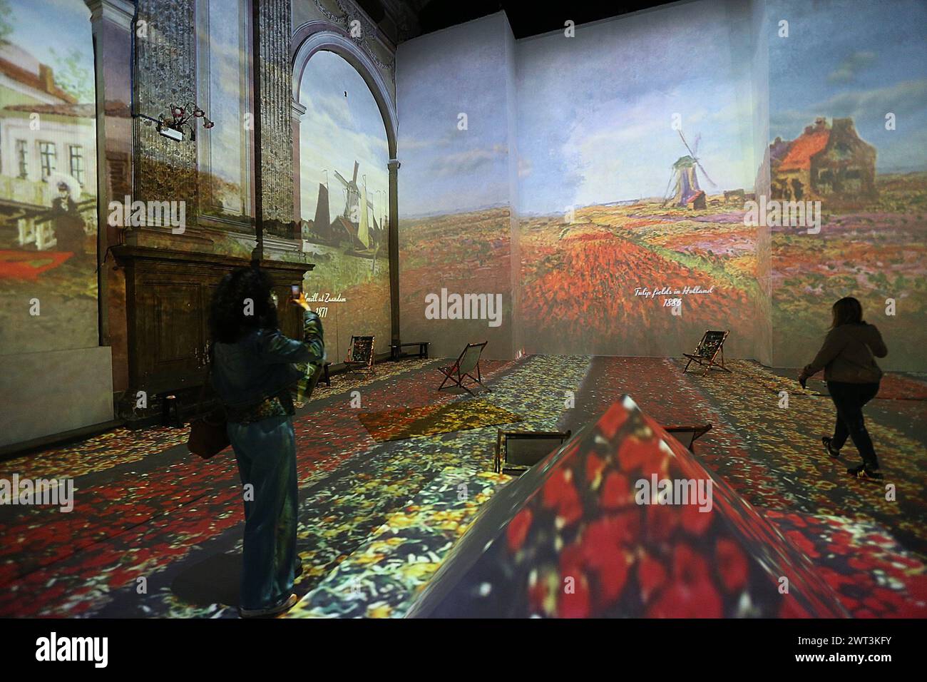 A visitor photographs a painting by Claude Monet projected on the wall ...