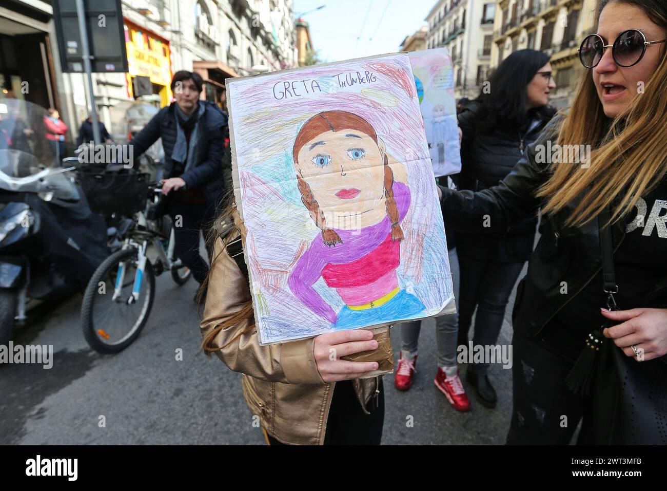 A young student girl covers herself with a drawing depicting the ...