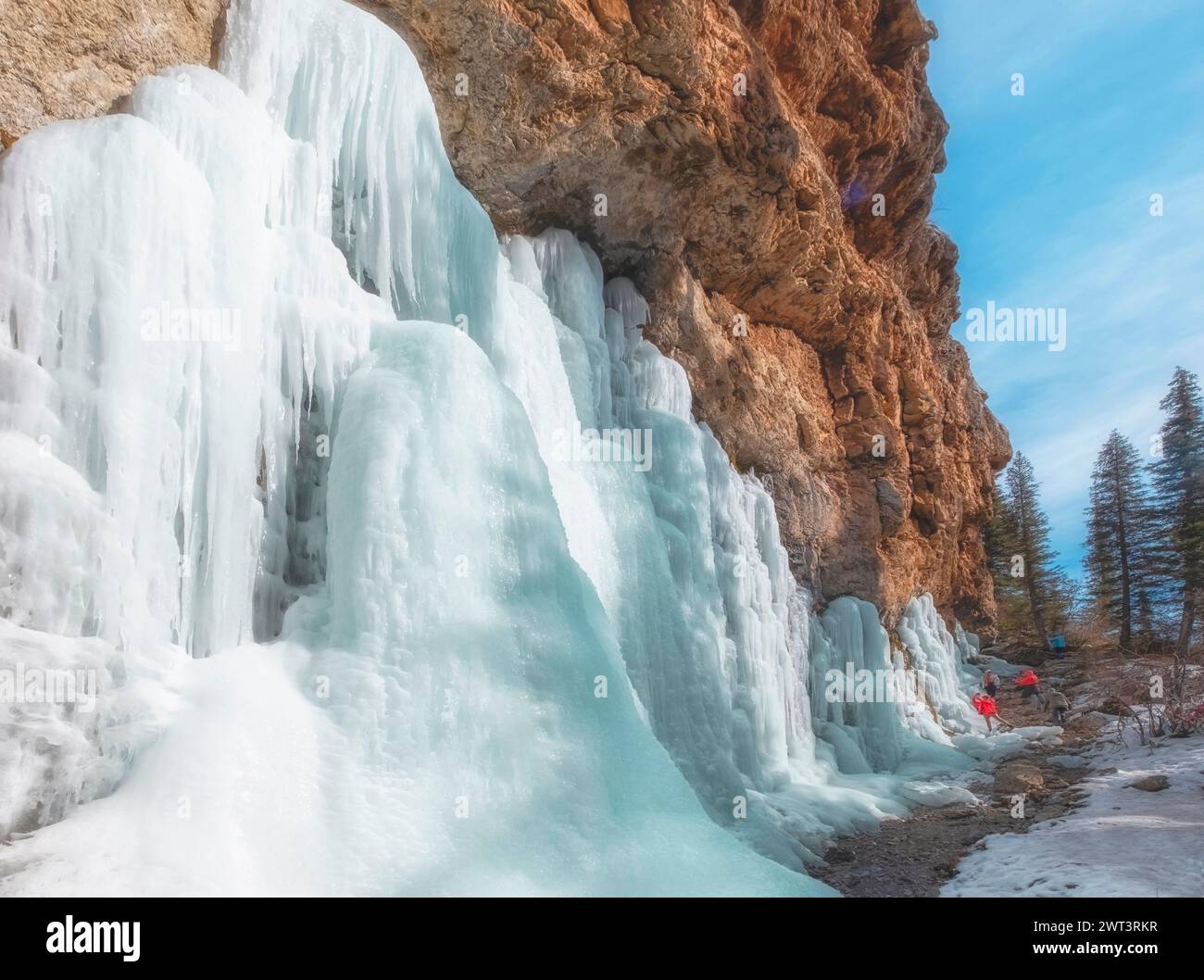 frozen waterfall with huge blue icicles and ice in the mountains ...