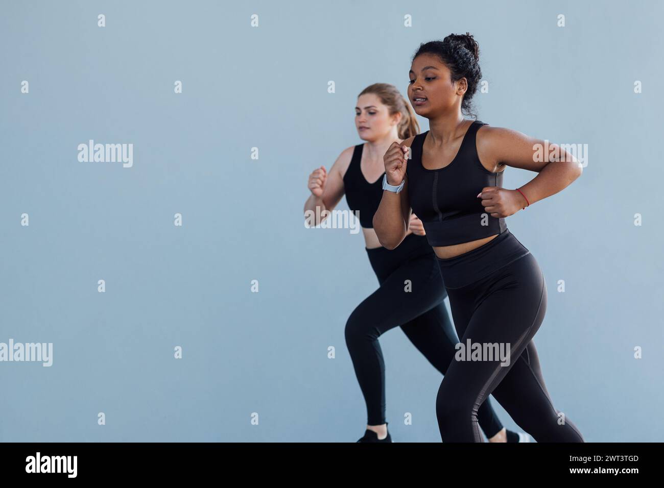 Two females competing each other while running outdoors. Young women ...