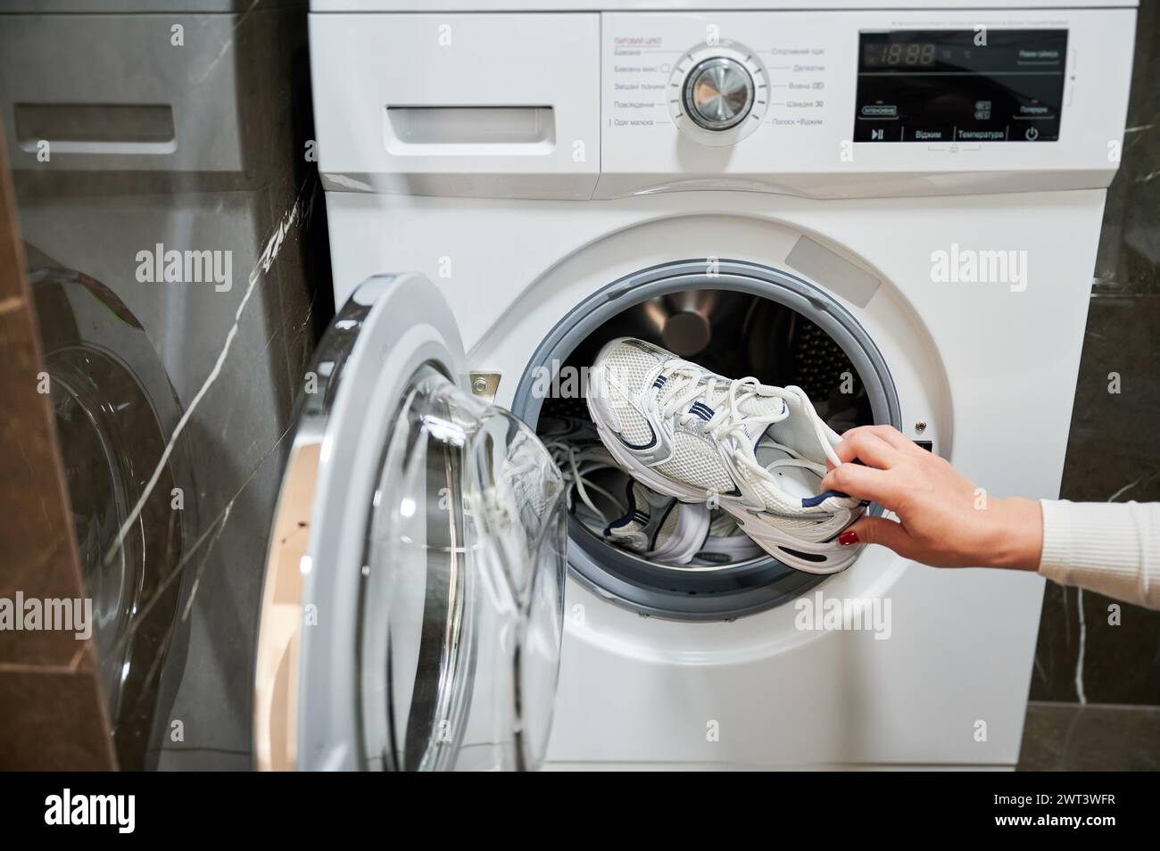 Dirty sport shoes need to be washed. Cropped photo of woman putting ...