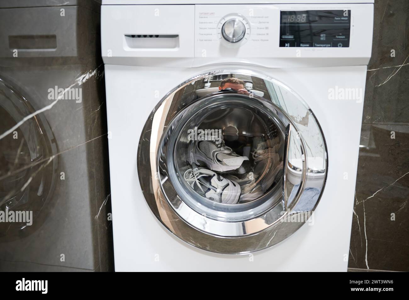 Close up photo of sneakers in washing machine. Washing shoes after walk ...