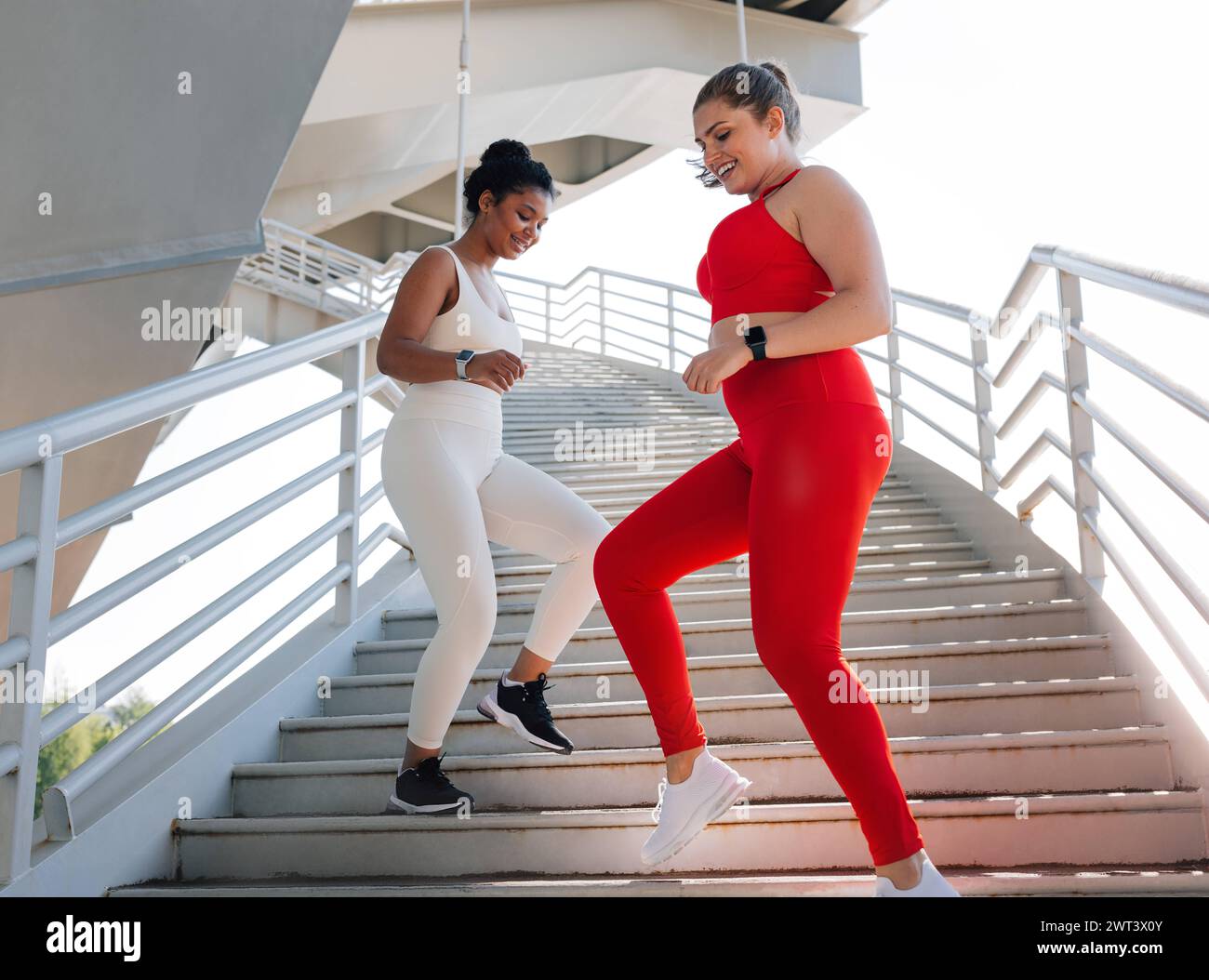 Two young plus-size females running together downstairs while ...