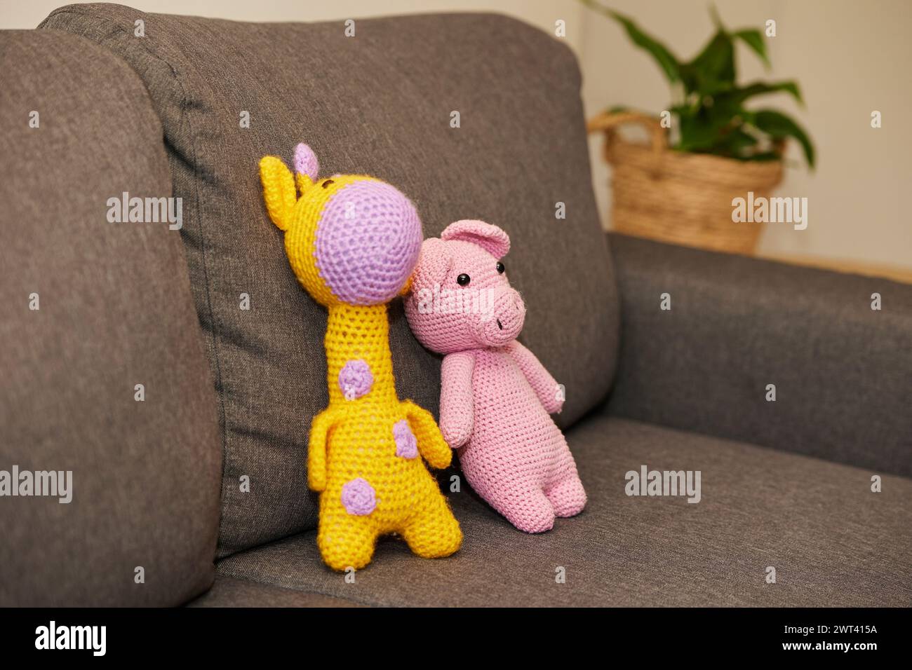 Knitted giraffe and pig on the sofa Stock Photo - Alamy