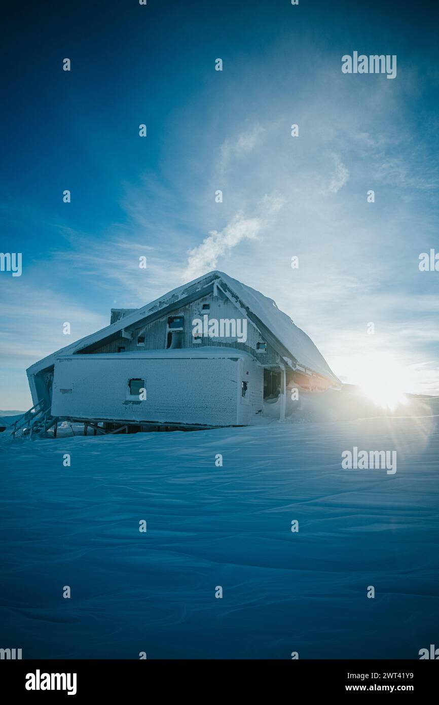 A winter scene with a house in snow, sun shining Stock Photo - Alamy