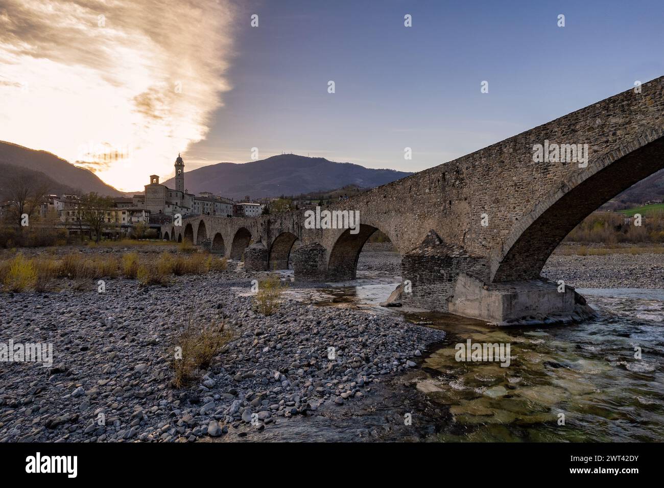 Aerial view of Bobbio town and Gobbo Bridge of Devil at sunset. Trebbia ...