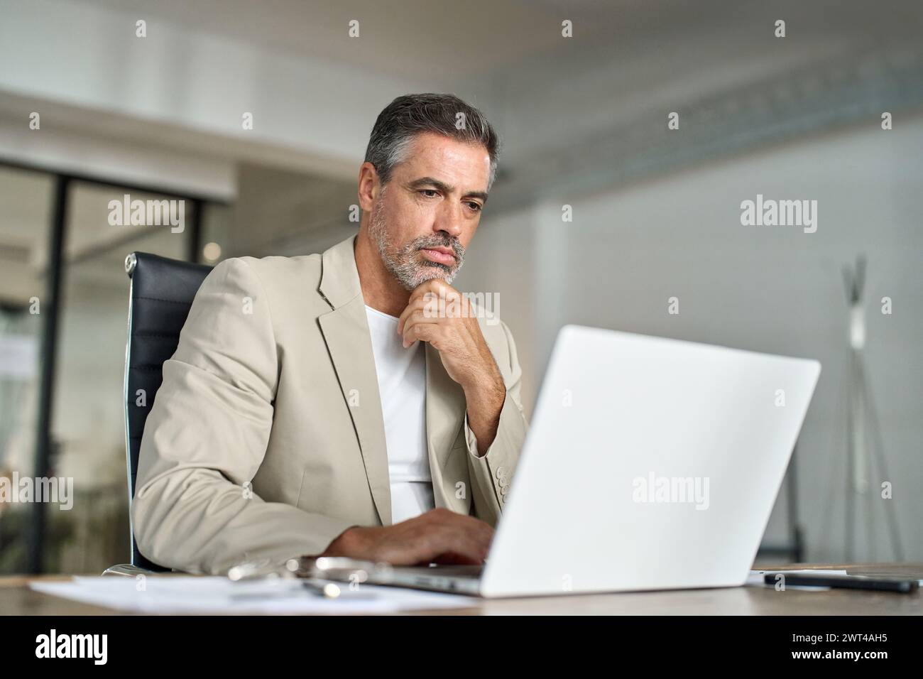 Busy mature professional business man looking at laptop working at ...