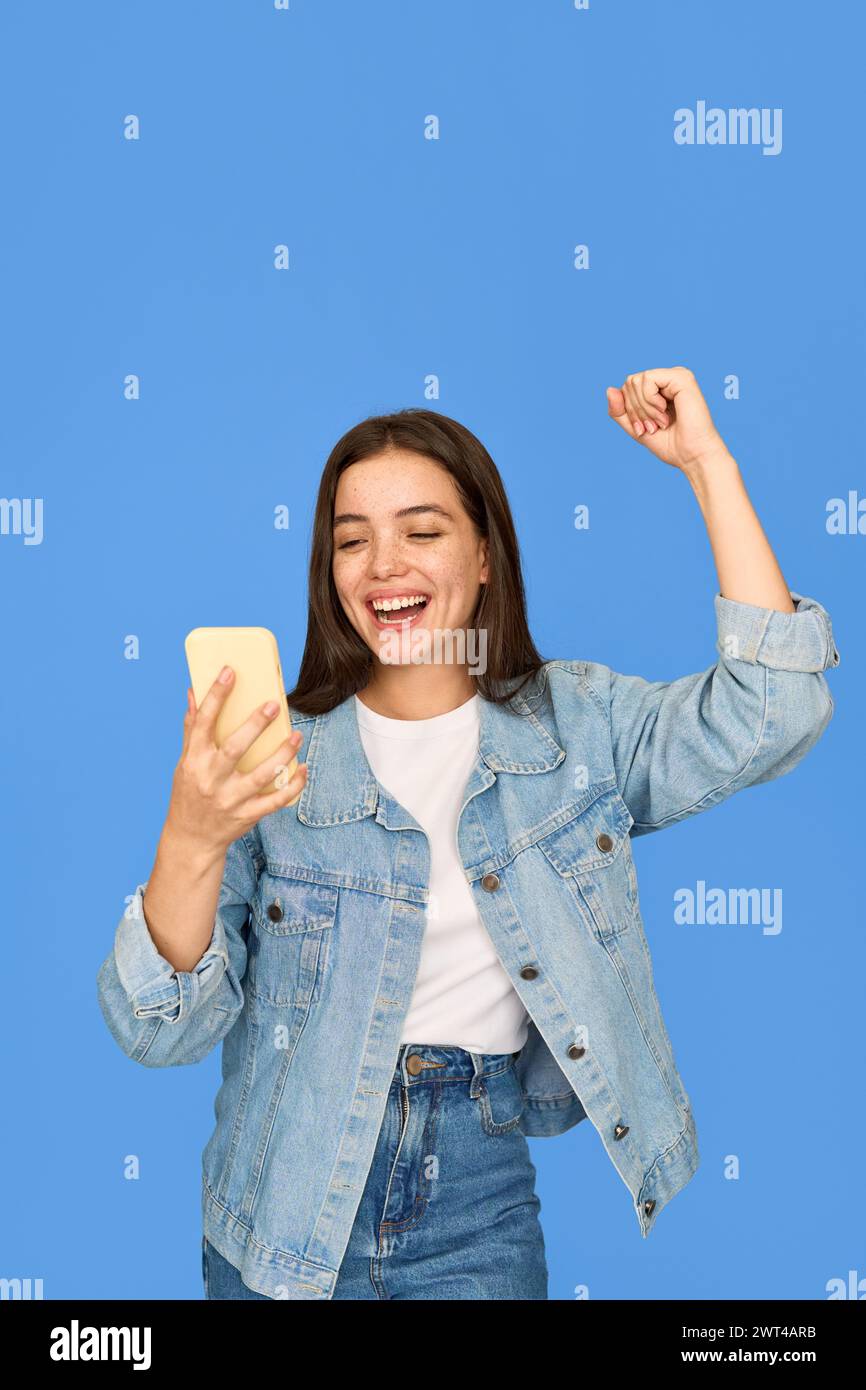 Excited gen z Latin girl celebrating win using mobile cell phone on ...