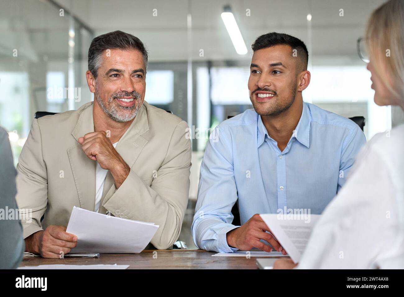 Happy busy business people working together talking at meeting table ...