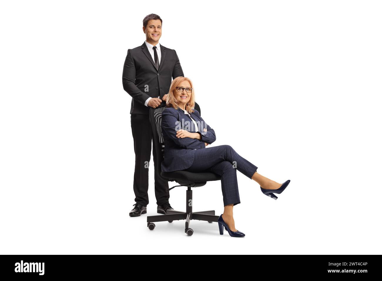 Young businessman standing behind a woman boss sitting in an office ...