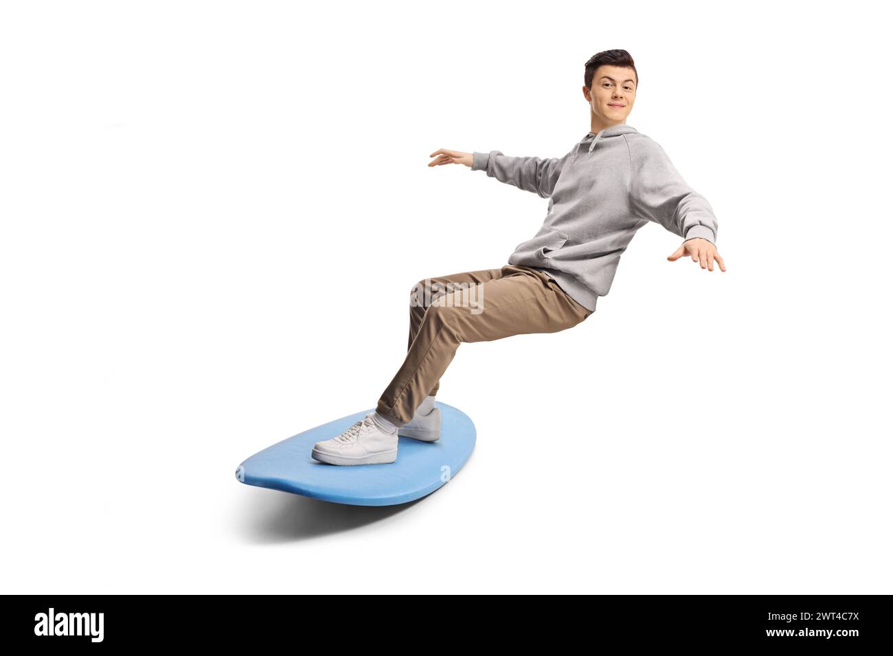 Male teenager surfing with clothes on isolated on white background ...