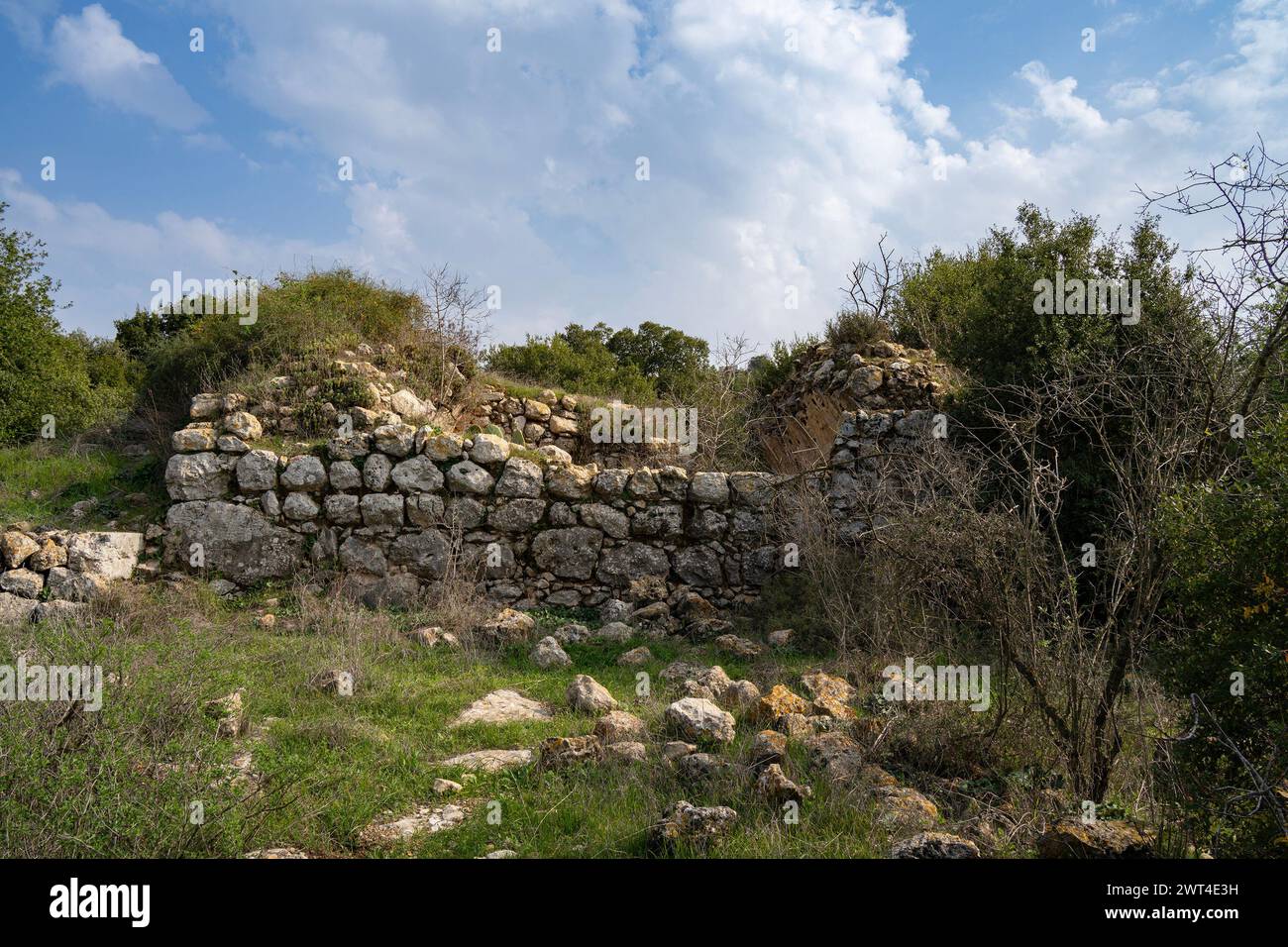 Ancient ruins of a stone structure, on a hill in a mediterranean ...