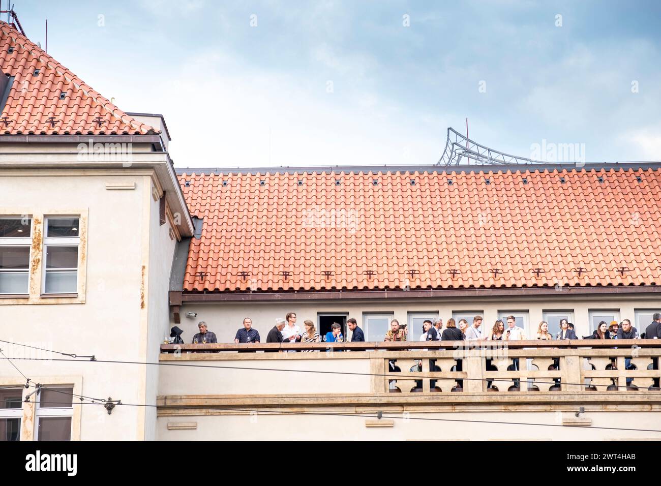 Group of people gathering on a rooftop terrace overlooking the city ...