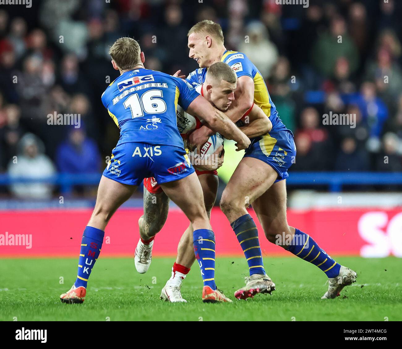 Jake Wingfield of St. Helens is tackled by James McDonnell of Leeds ...