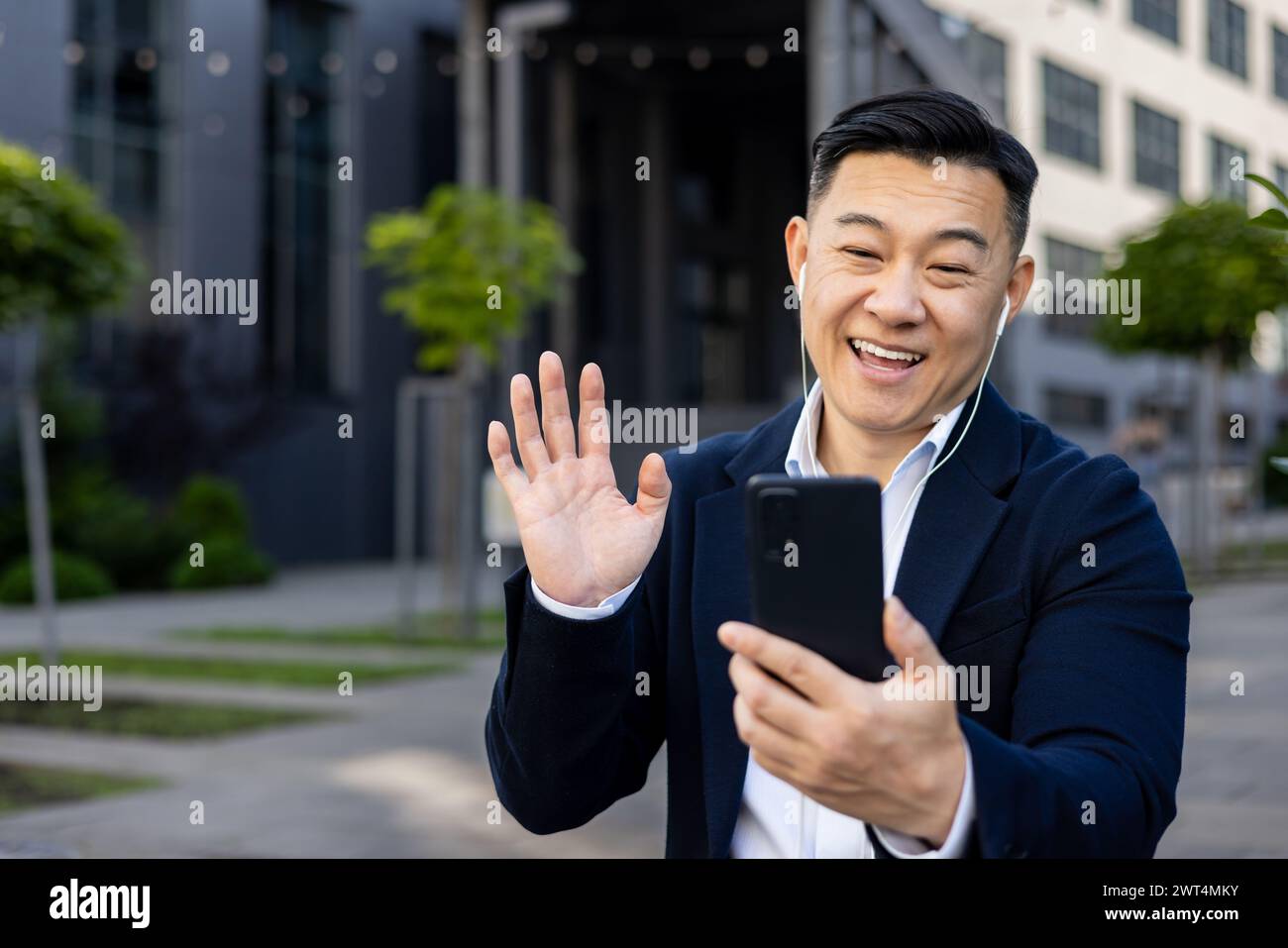 Happy professional man engaging in a video call, waving hello to ...